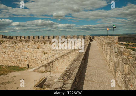 Pathway on top of thick stone wall with crenel and merlons at the ...