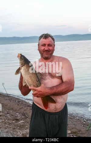 Stocky man with fish. Khakassia, Russia Stock Photo - Alamy
