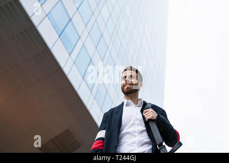 Stylish businessman in front of office building looking around Stock ...
