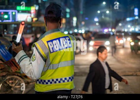 Traffic police officer with safety vest and white gloves regulating ...