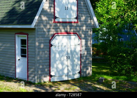 Small gray barn in the backyard. White doors Stock Photo - Alamy