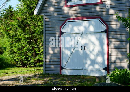 Small gray barn in the backyard. White doors Stock Photo - Alamy