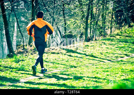 Man jogging or running along river towpath with 2 dogs getting morning ...