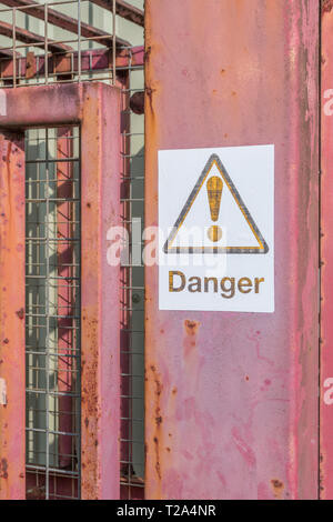 Fading DANGER warning sign in an industrial area. Factory warning signs ...