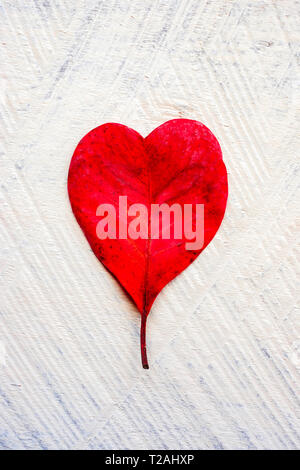 Red color heart shaped object on finger on brown Stock Photo - Alamy