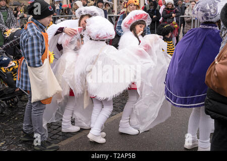 majorettes marching wrapped up against rain at Carnival parade ...