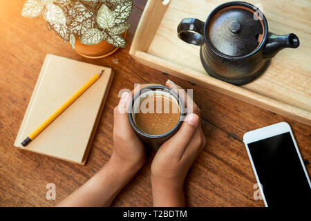 Hands closeup of woman drinking at cafe holding a coffee cup with a ...