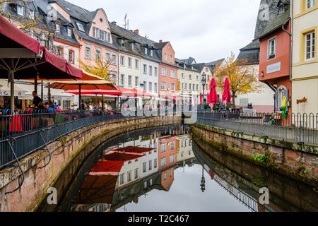 Restaurant terraces along the river Saar in the center of Saarburg ...