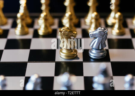 Closeup shot of chess knights placed on chessboard in front of each ...