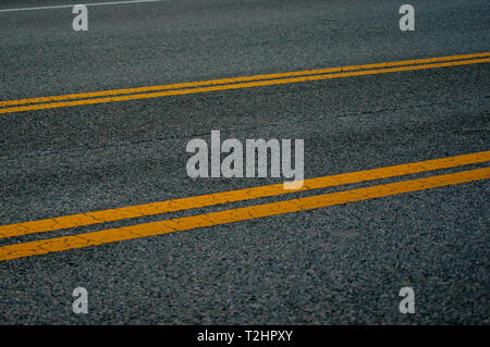 Highway road marking. Yellow, white and red lines over dark asphalt ...