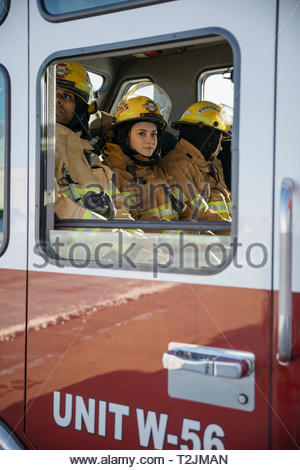 Woman in uniform of firefighter posing in profile with air tank and ...