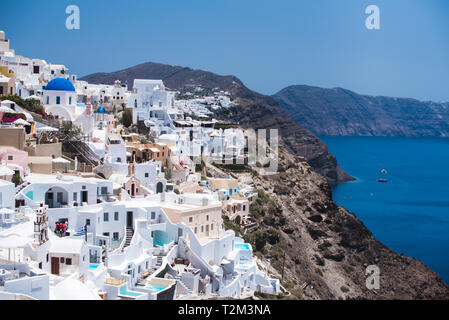 A colorful Greek village sits on a cliff-side in Santorini Stock Photo ...