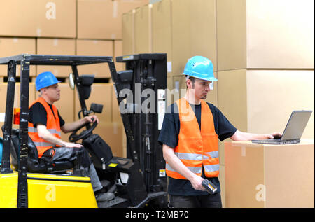 worker with notebook and barcode scanner handles a shipment in the ...