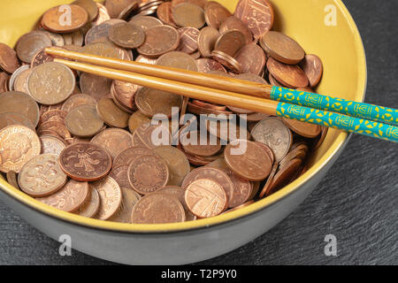 Bowl full of coins of the pound sterling and spoon .Concept Stock Photo ...