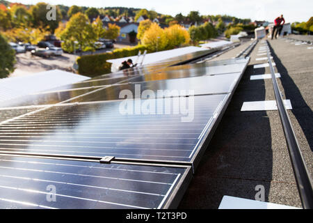 Handyman, with safety harness and safety line, assembles solar cells on ...
