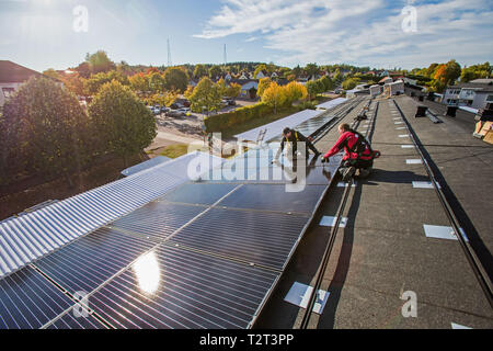 Handyman, with safety harness and safety line, assembles solar cells on ...