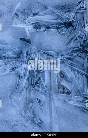 ice crystals form an intricate pattern on inside of glass window during ...