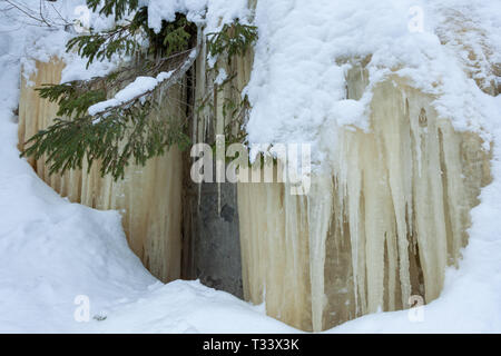 Icicles hanging over rock in the forest winter Stock Photo - Alamy