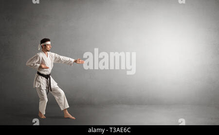 Small karate man fighting in an empty grey copy space Stock Photo - Alamy