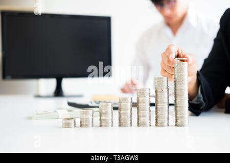 Midsection of businessman hand put stacking coins at on Increasing coin ...