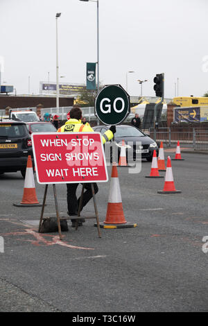 Workmen manually controlling traffic with stop and go signs Stock Photo ...