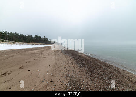 empty sea beach with ice leftovers and no snow in winter Stock Photo ...