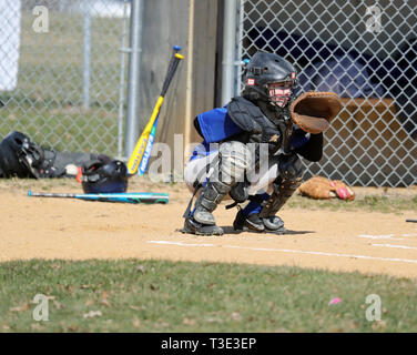 Baseball Catcher behind home plate. Shot from behind a chain link fence ...