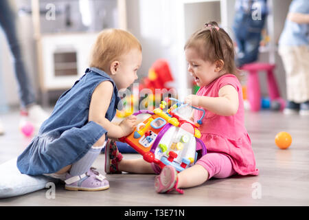 Kids fighting over a toy Stock Photo - Alamy