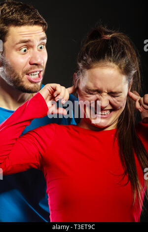 Husband abusing wife. Aggresive man screaming at crying scared woman ...
