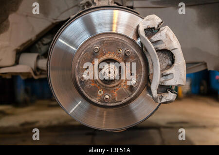 Heavily worn brake disc. Car brake disc after removing the wheel. A ...