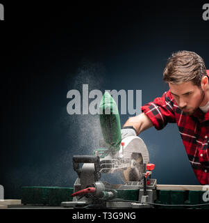 handsome man carpenter using a circular saw Stock Photo - Alamy