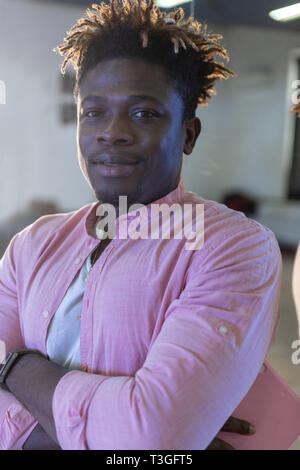 The African man stand with his hands crossed and gave a friendly smile ...