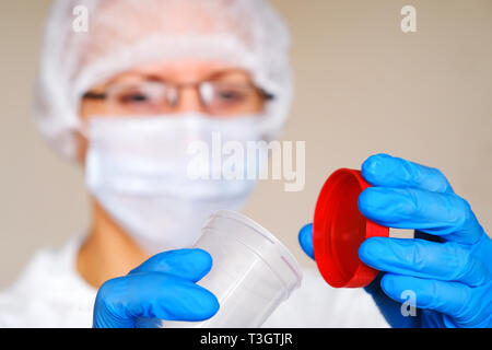Lab technician, medic. Jar for analysis. On the face of a protective ...