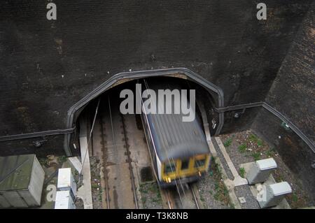 London underground tube train emerging from a tunnel on the northern ...