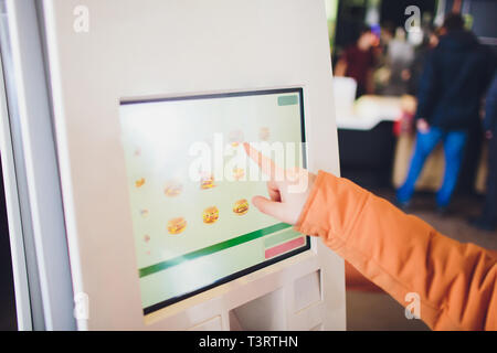 woman orders meal in the electronic touch screen terminal menu in the ...