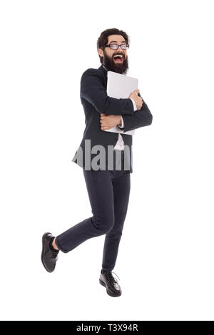 Businessman hugging laptop at studio Stock Photo - Alamy