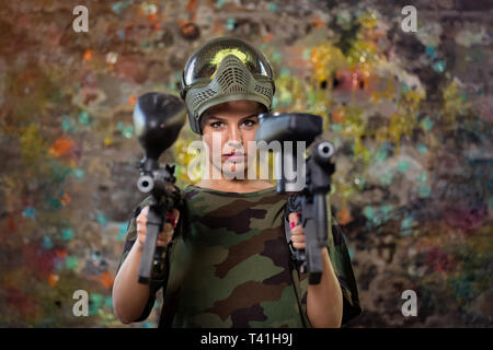 Girl paintballer with marker gun and mask Stock Photo - Alamy