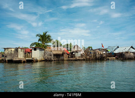 Traditional Kuna housing (rural thatch houses) with busy yard. Carti ...