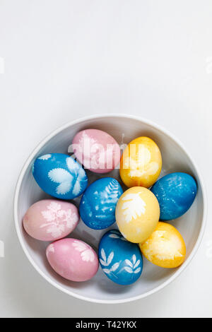 Yellow handmade Easter egg with decorative patterns hanging on a tree ...