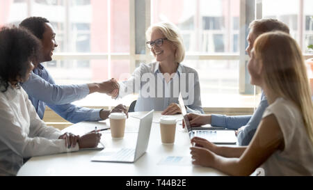 Happy businessman and woman handshaking after successful deal at office ...