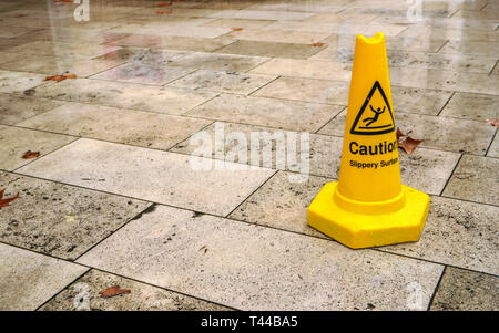Yellow Caution Slippery Surface cone Stock Photo - Alamy