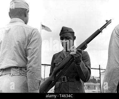 U.S. Marine Corps Cpl. Edgar R. Huff inspects a weapon at Montford ...