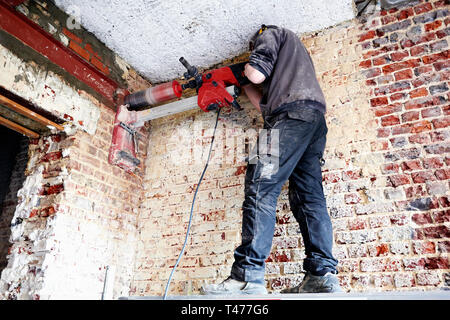 Drilling a hole in a brick wall with a masonry drill Stock Photo - Alamy