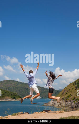 Young couple jumping, beautiful sea view on background Stock Photo - Alamy