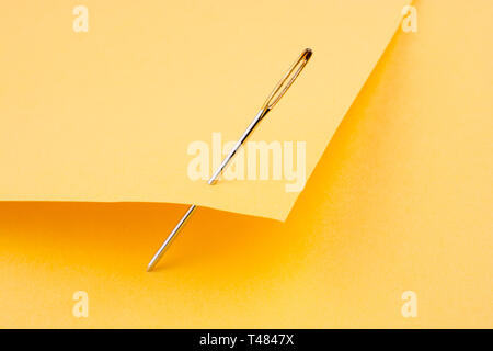 Needle pierced yellow color note paper Stock Photo - Alamy