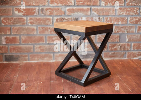 stylish stool against a red brick wall. photo with copy space Stock ...
