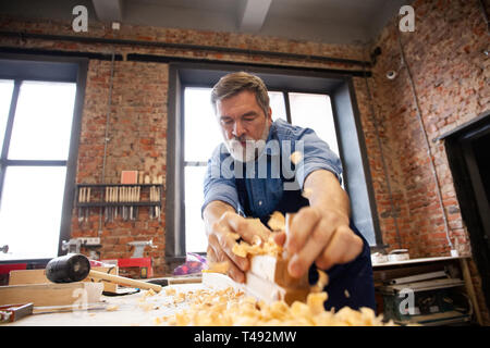 Mature handsome joiner work in carpentry. He is successful entrepreneur ...