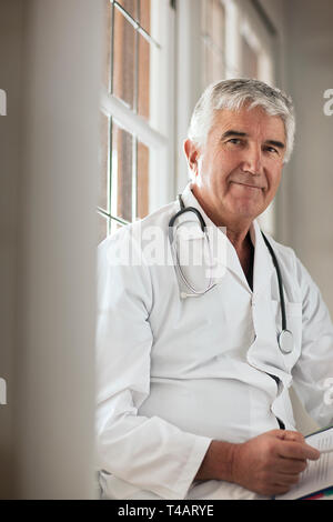 Happy doctor reading some notes Stock Photo - Alamy