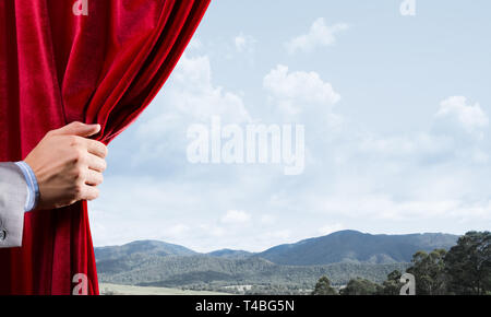 Human hand opens red curtain on natural landscape background Stock ...