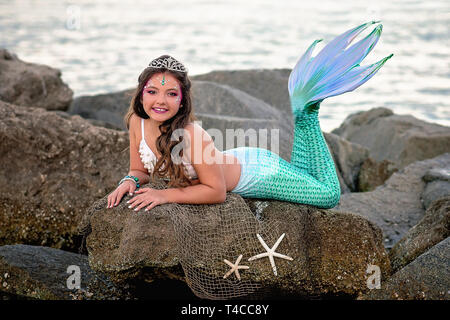 Tween mermaid on rocks Stock Photo - Alamy